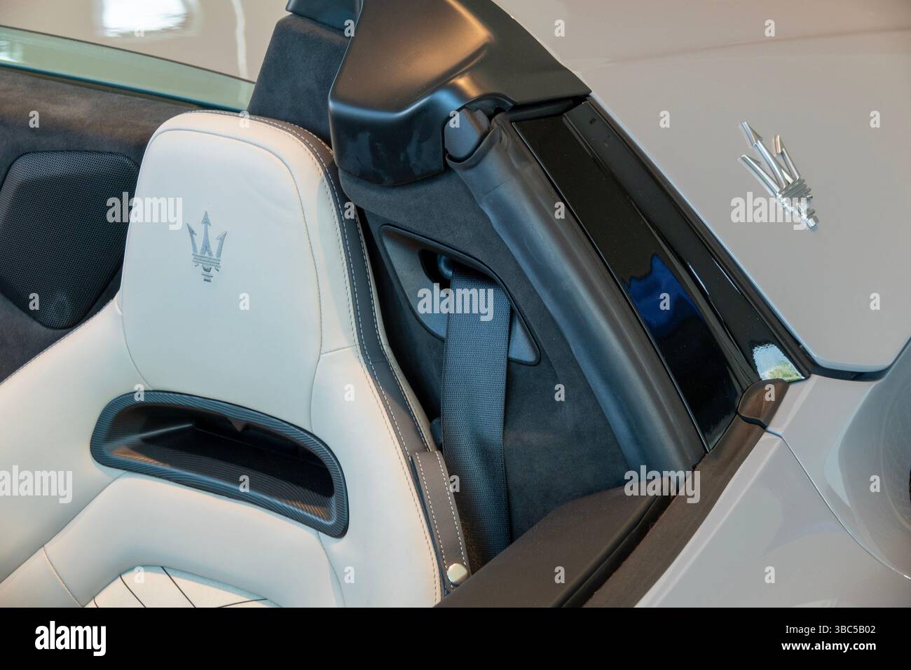 Maserati white leather seat with brand logos in a cabin of a hard top ...