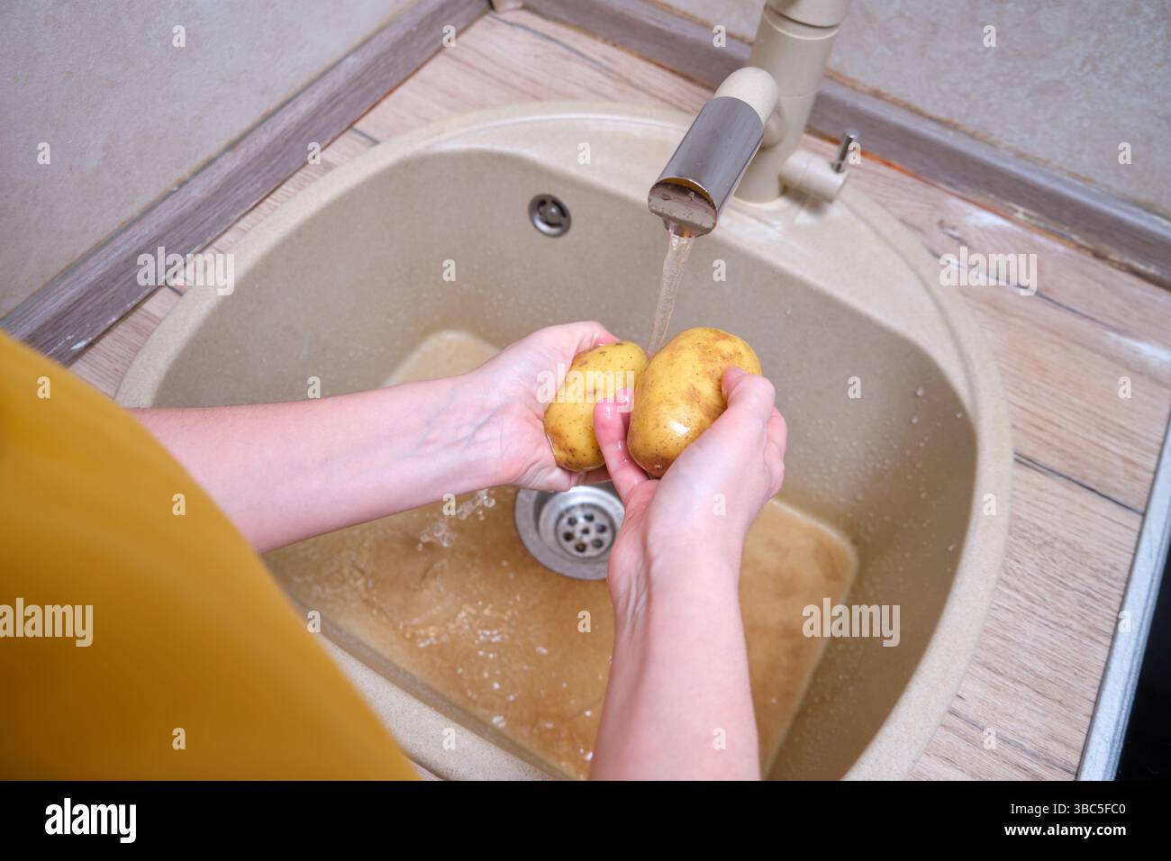 Washing potatoes in sink close hi-res stock photography and images - Alamy
