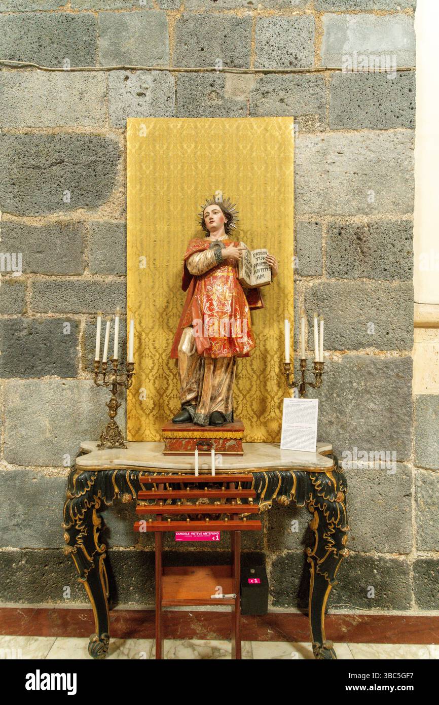 Saint statue with halo and stone wall backdrop Stock Photo - Alamy