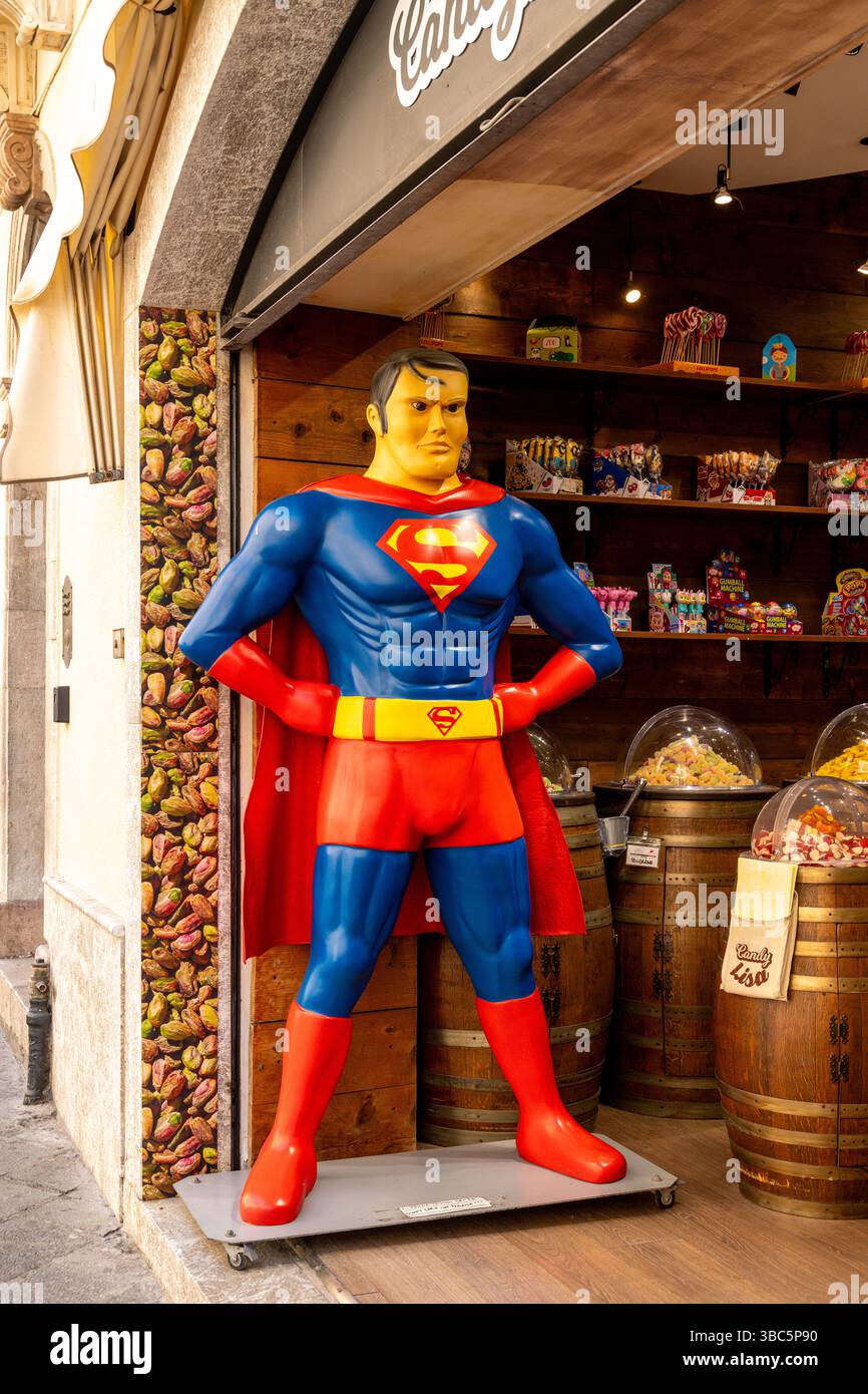 Superhero figure in front of candy shop Stock Photo - Alamy