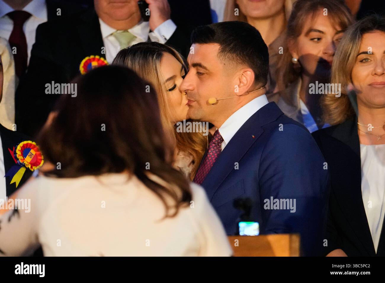 Presidential candidate George Simion, center right, kisses his wife ...