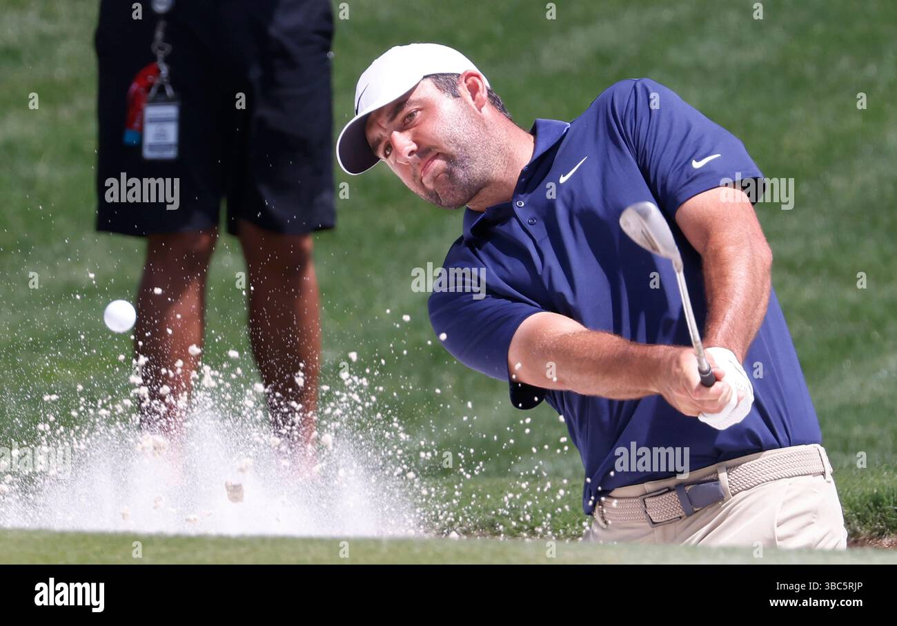 Scottie Scheffler chips out of a bunker on the 1st hole during the ...