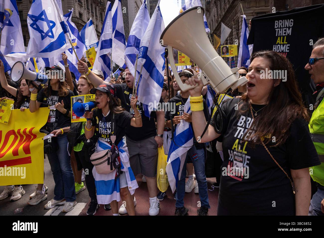 Former hostage families and supporters raise Israeli flags and signs as ...