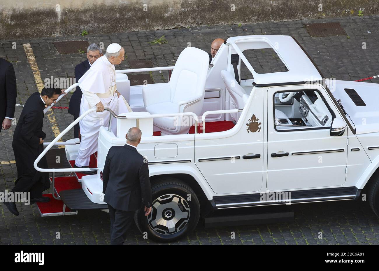 Pope Leo XIV climbs into the popemobile before entering St. Peter's ...
