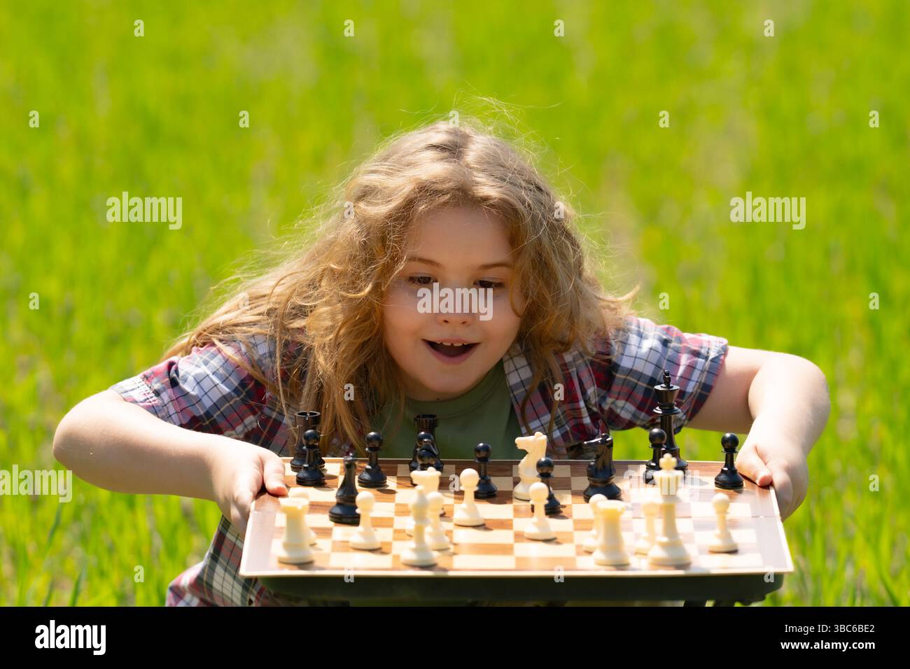 The kid plays chess. A clever child thinks and playing chess. Kid ...