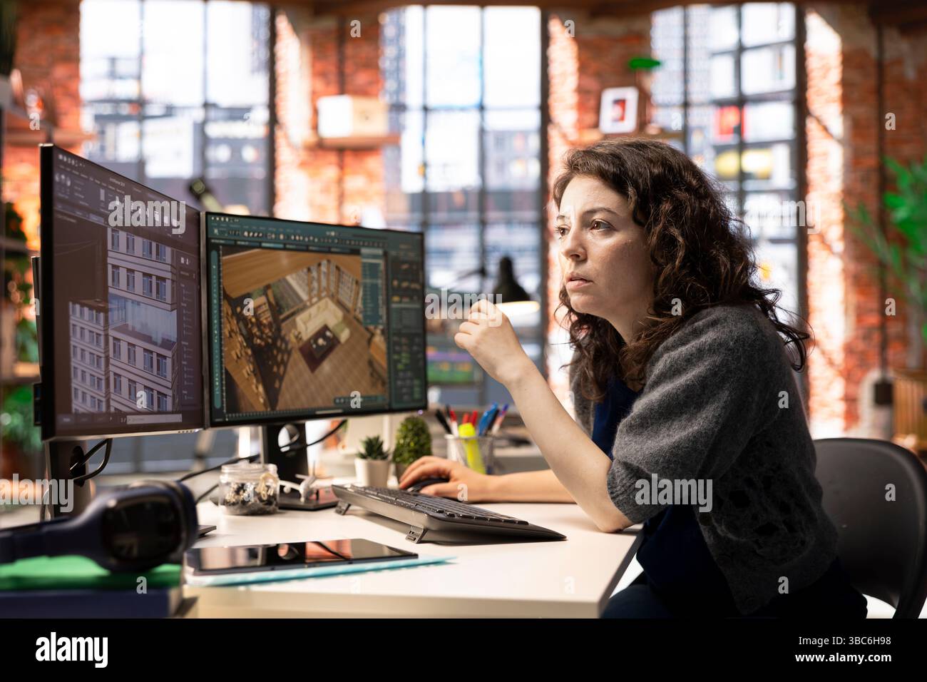 Worker in a creative office uses CAD software to design a house ...
