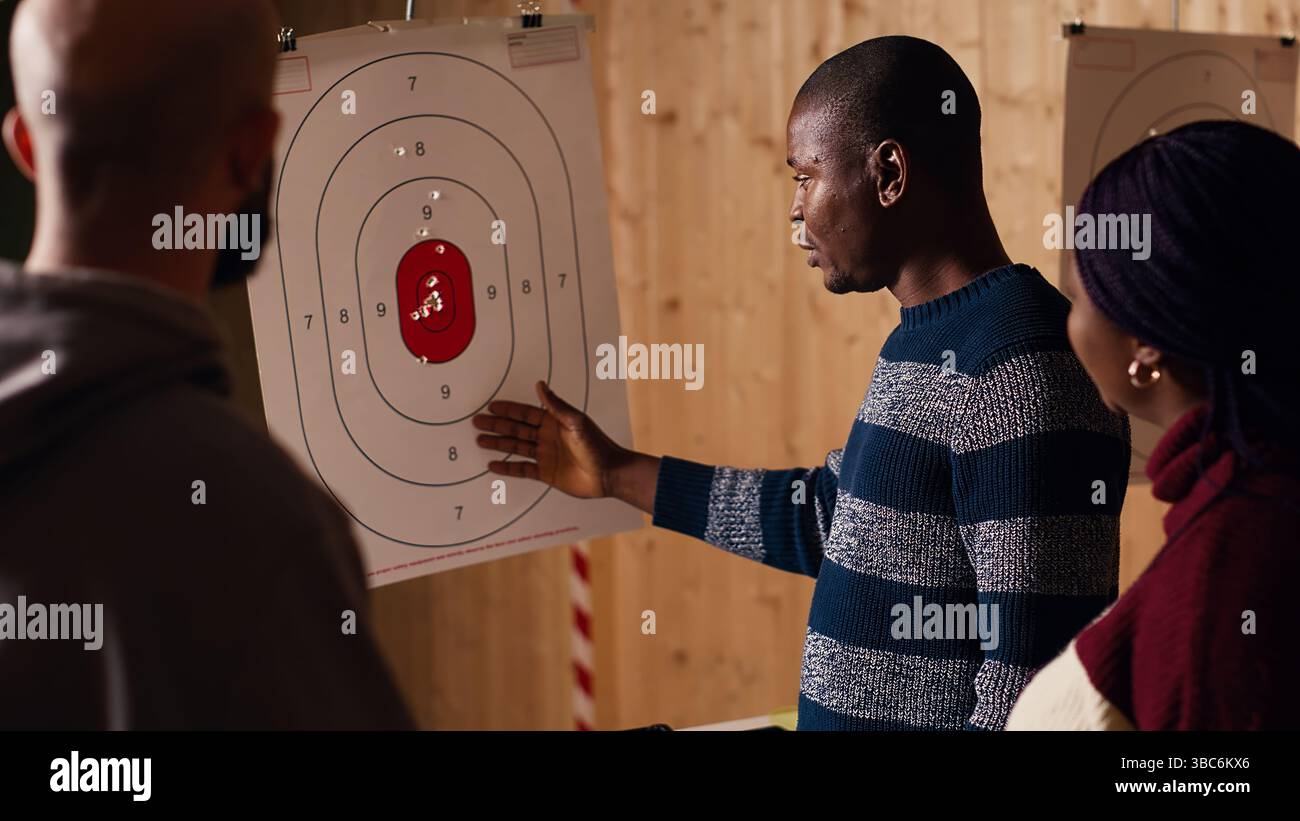 Shooting range safety officer explaining bullseye scoring system to ...