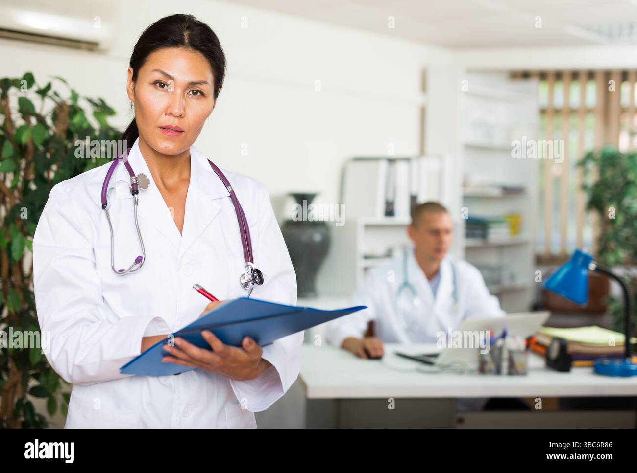Asian woman general practitioner writing medical history sheet Stock ...