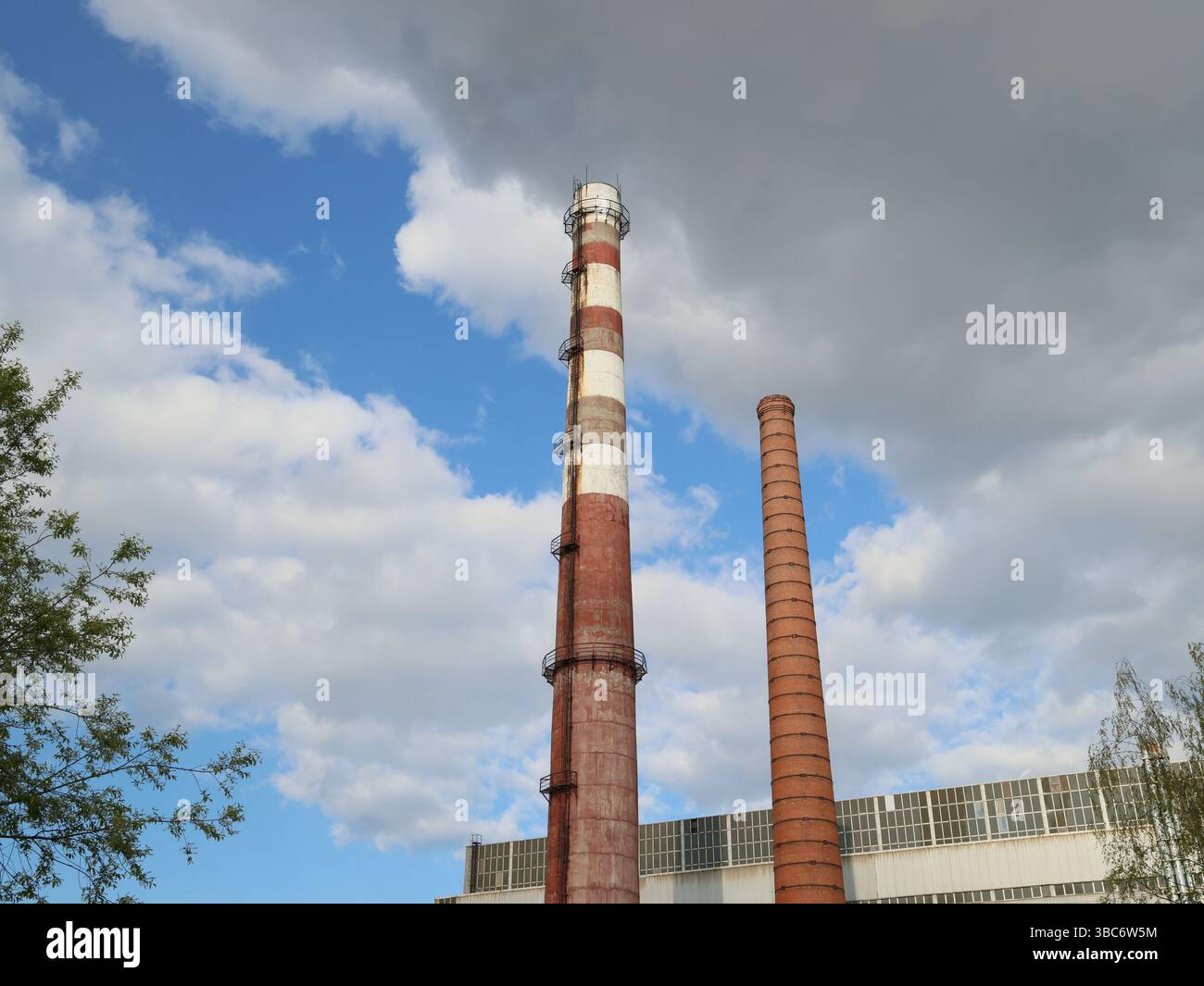 Industrial smokestacks stand prominently against a strikingly dramatic ...