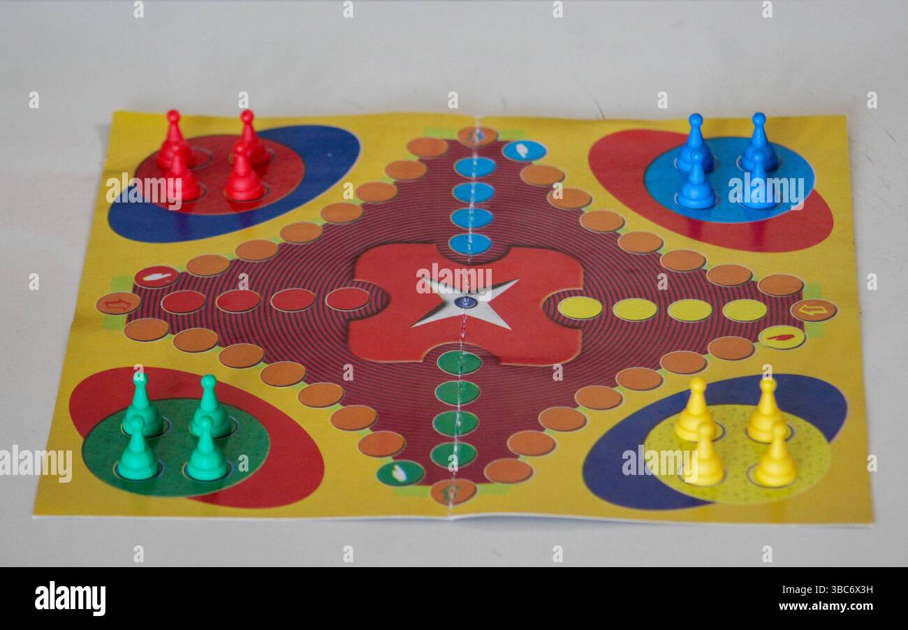 Ludo board game setup with red, blue, green, and yellow playing pieces ...