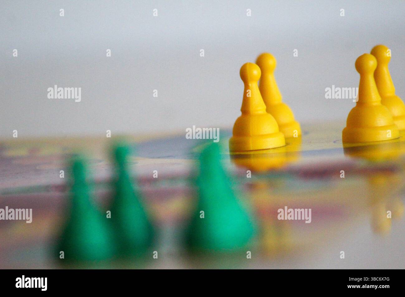 Close-up of yellow and green playing pawns from the classic Ludo board ...