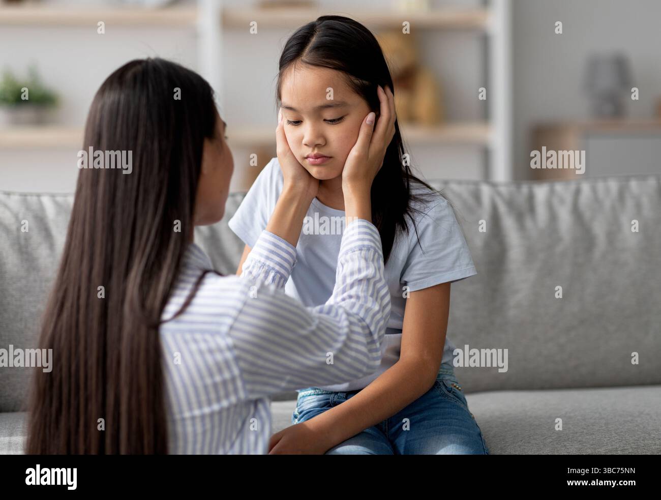 Family misunderstanding concept. Young asian mother calming down her ...