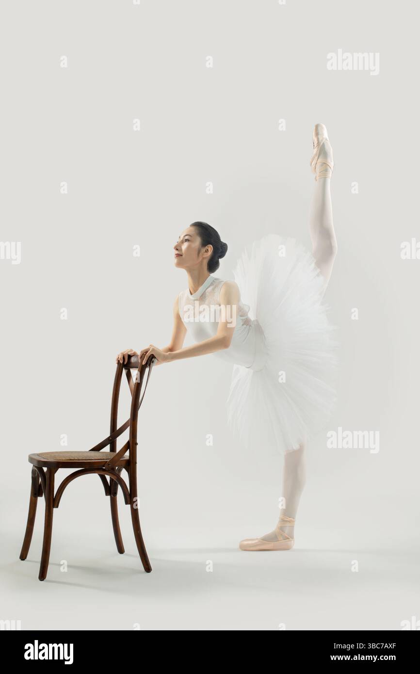 a ballet dancer leaning on a chair while dancing Stock Photo - Alamy