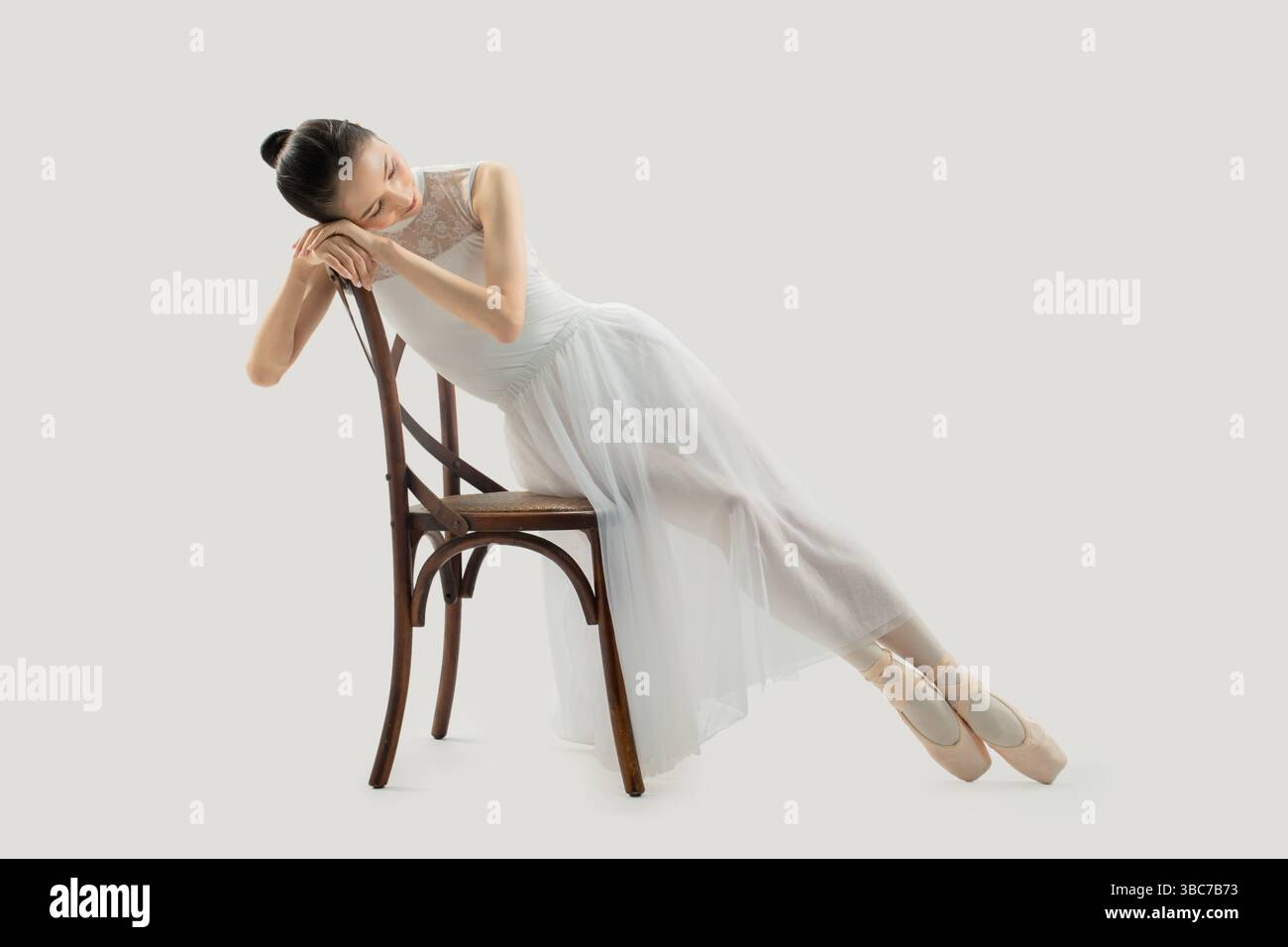 a ballet dancer leaning on a chair while dancing Stock Photo - Alamy