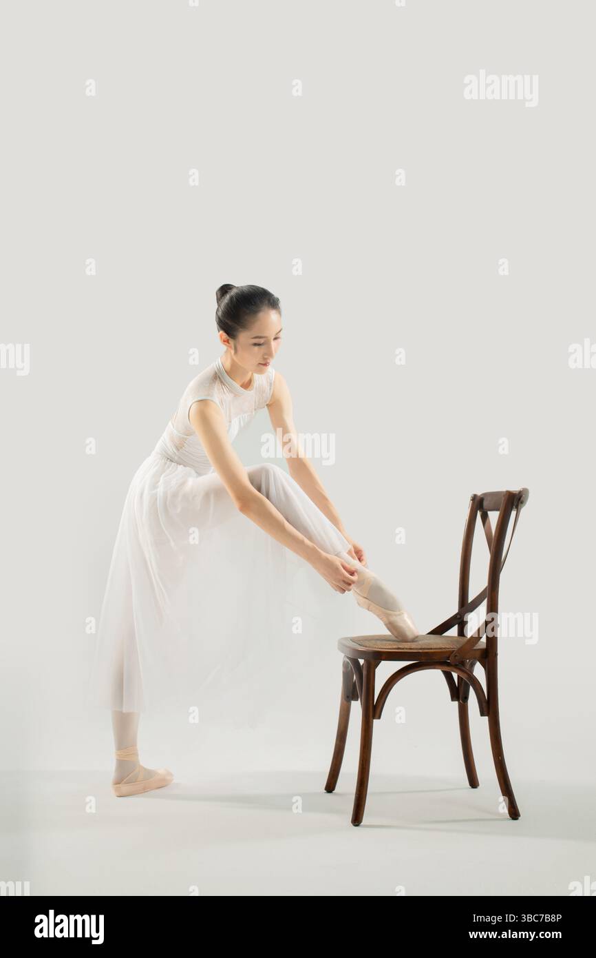a ballet dancer leaning on a chair while dancing Stock Photo - Alamy