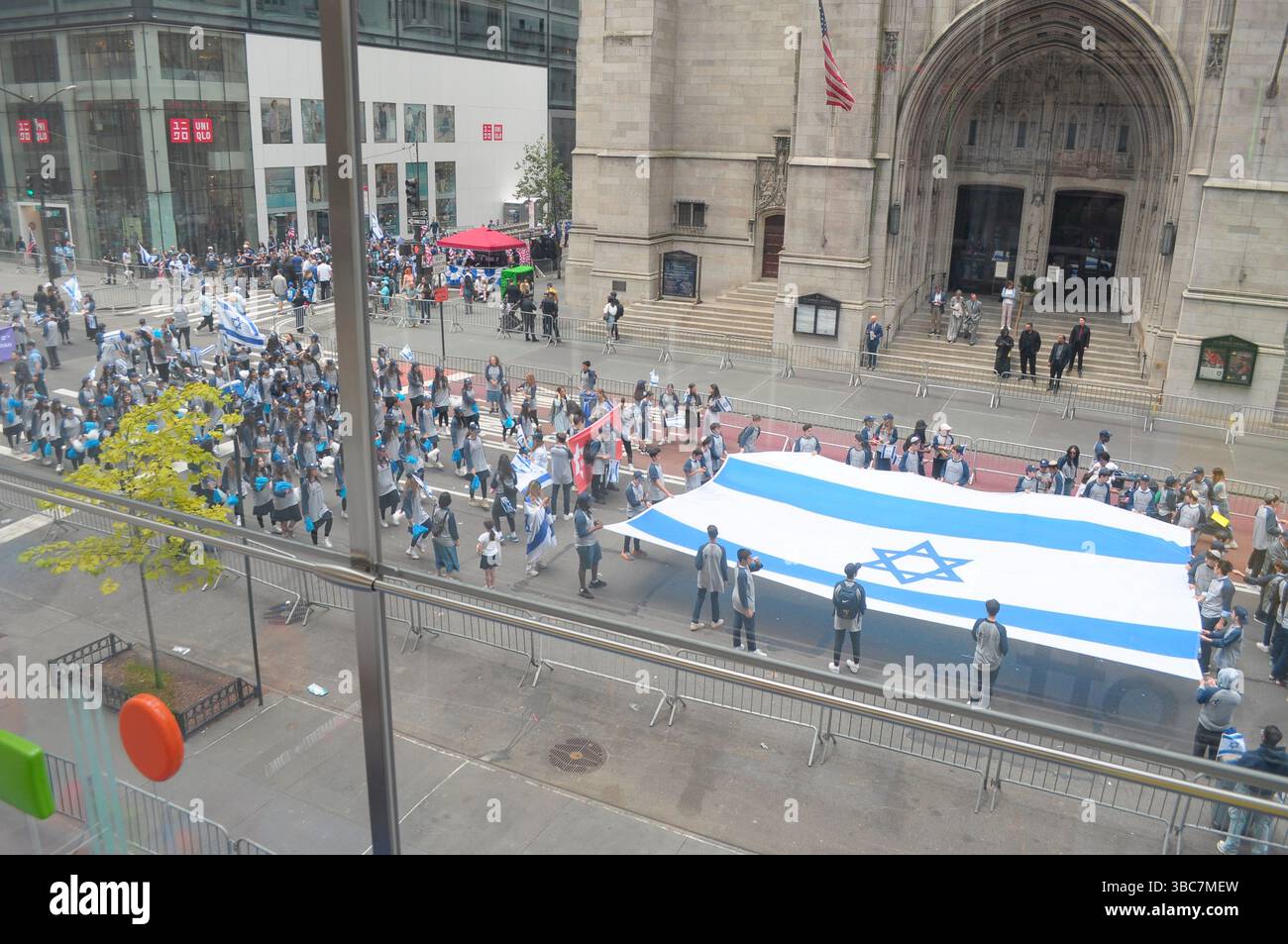 Parade participants hold a large Israeli flag while marching at the ...