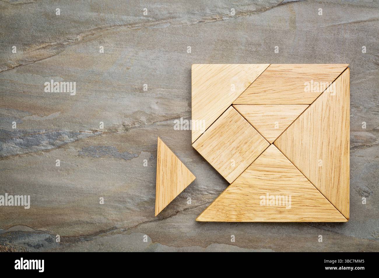 A missing piece in a square built from tangram pieces, a traditional ...