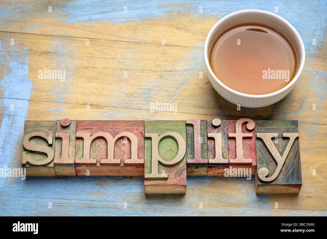 Simplify - text in letterpress wood type with a cup of tea, business or ...