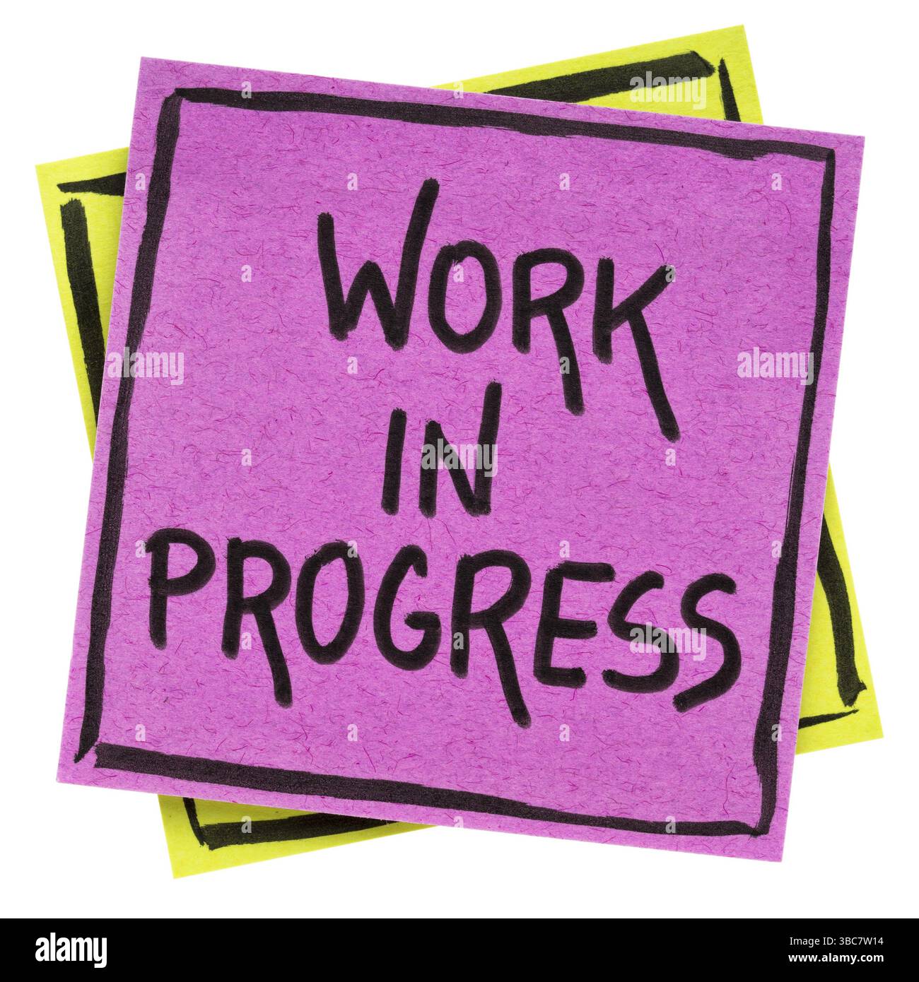 Work in progress - handwriting in black ink on an isolated sticky note ...