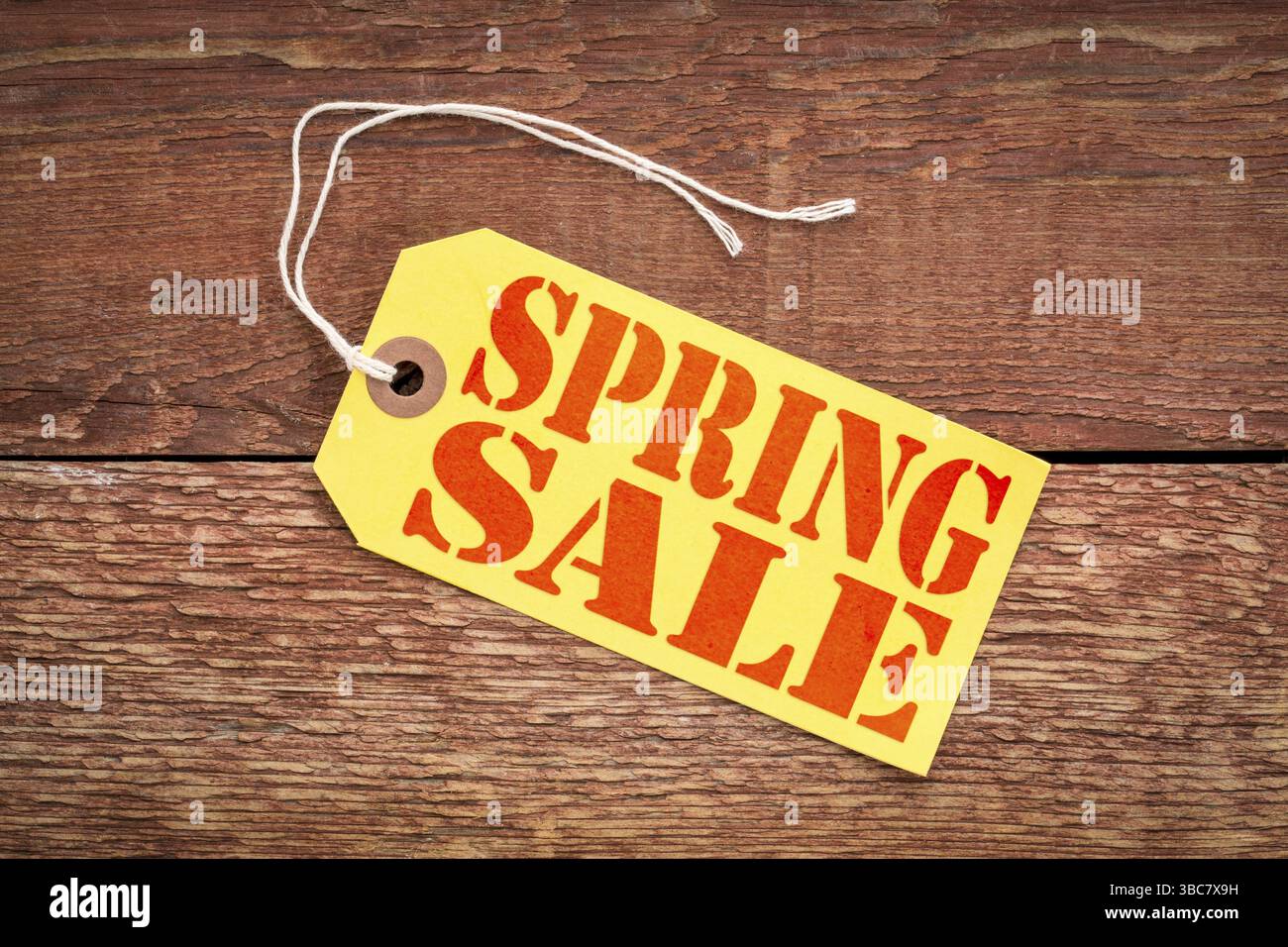 Spring sale sign - red stencil text on a yellow paper price tag against ...