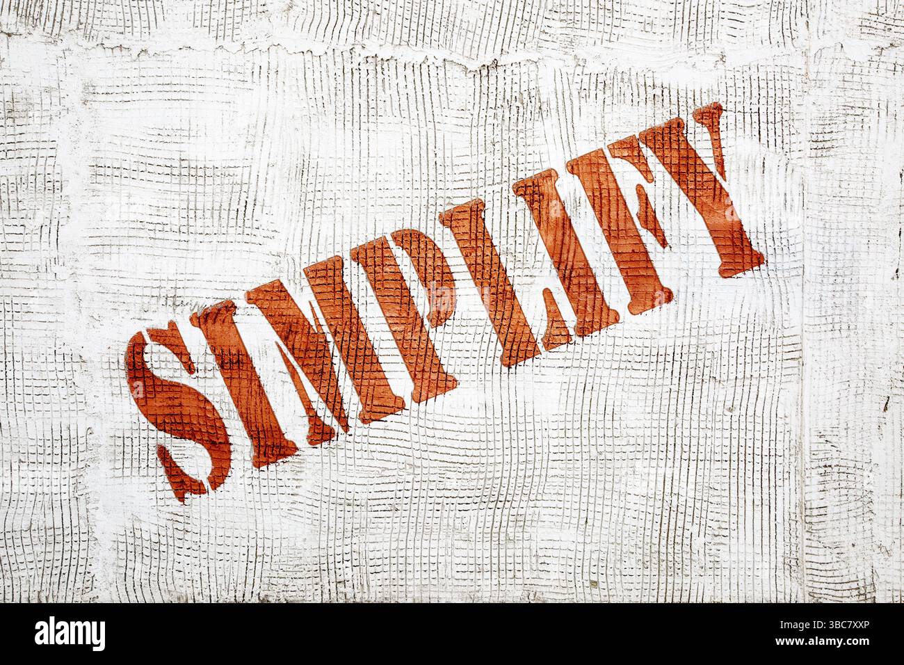 Simplify - red graffiti style sign on a white stucco wall Stock Photo ...