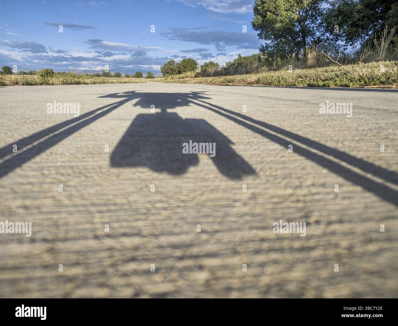 Shadow of a hexacopter drone taking off with a camera from a concrete ...
