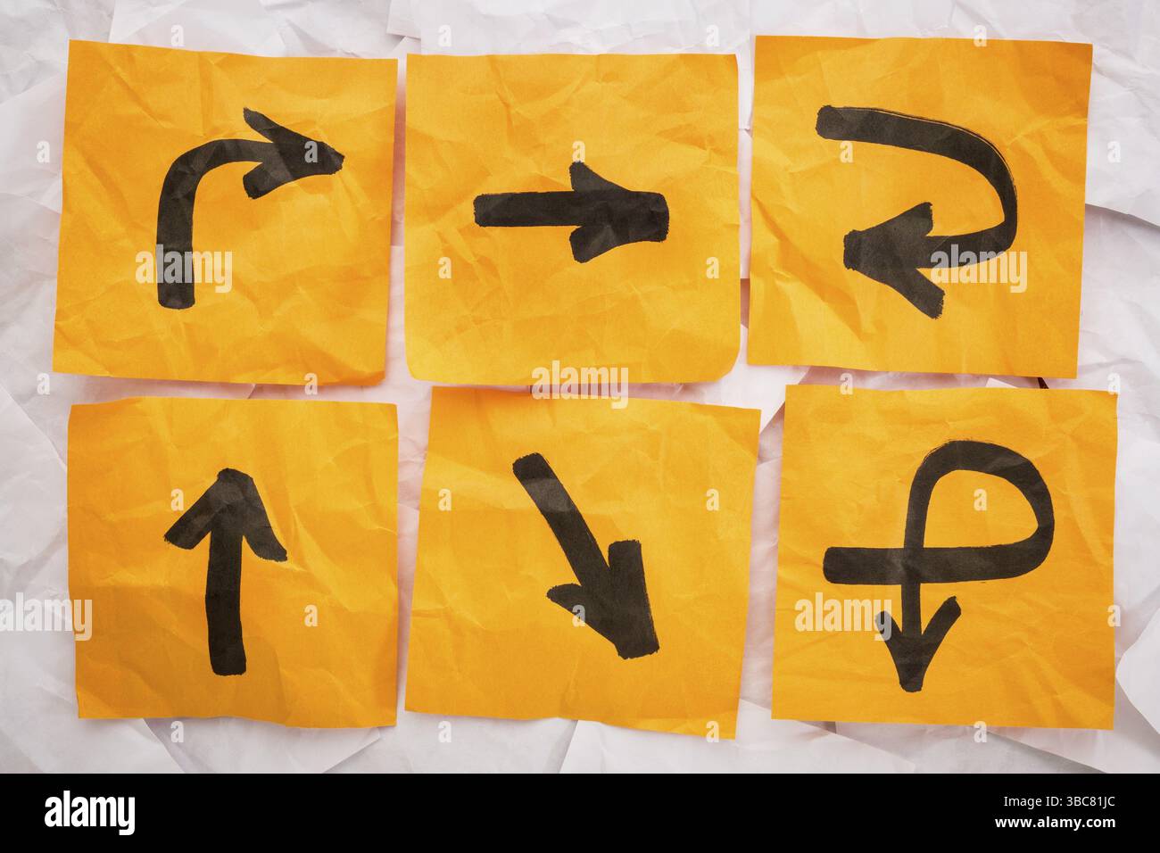 Confusing directions concept - a variety of arrows on crumpled, orange ...