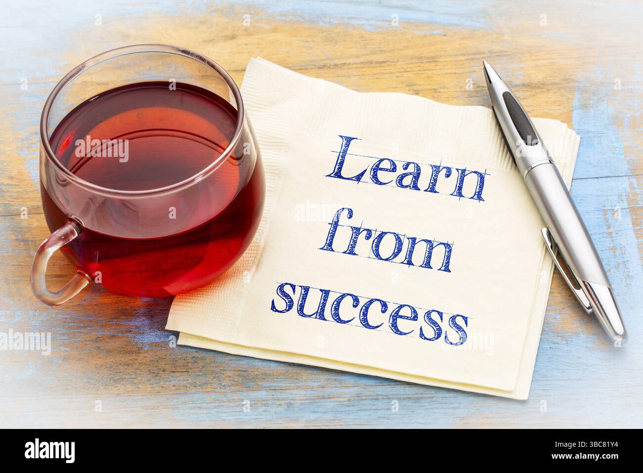 Learn from success advice - handwriting on a napkin with a cup of tea ...