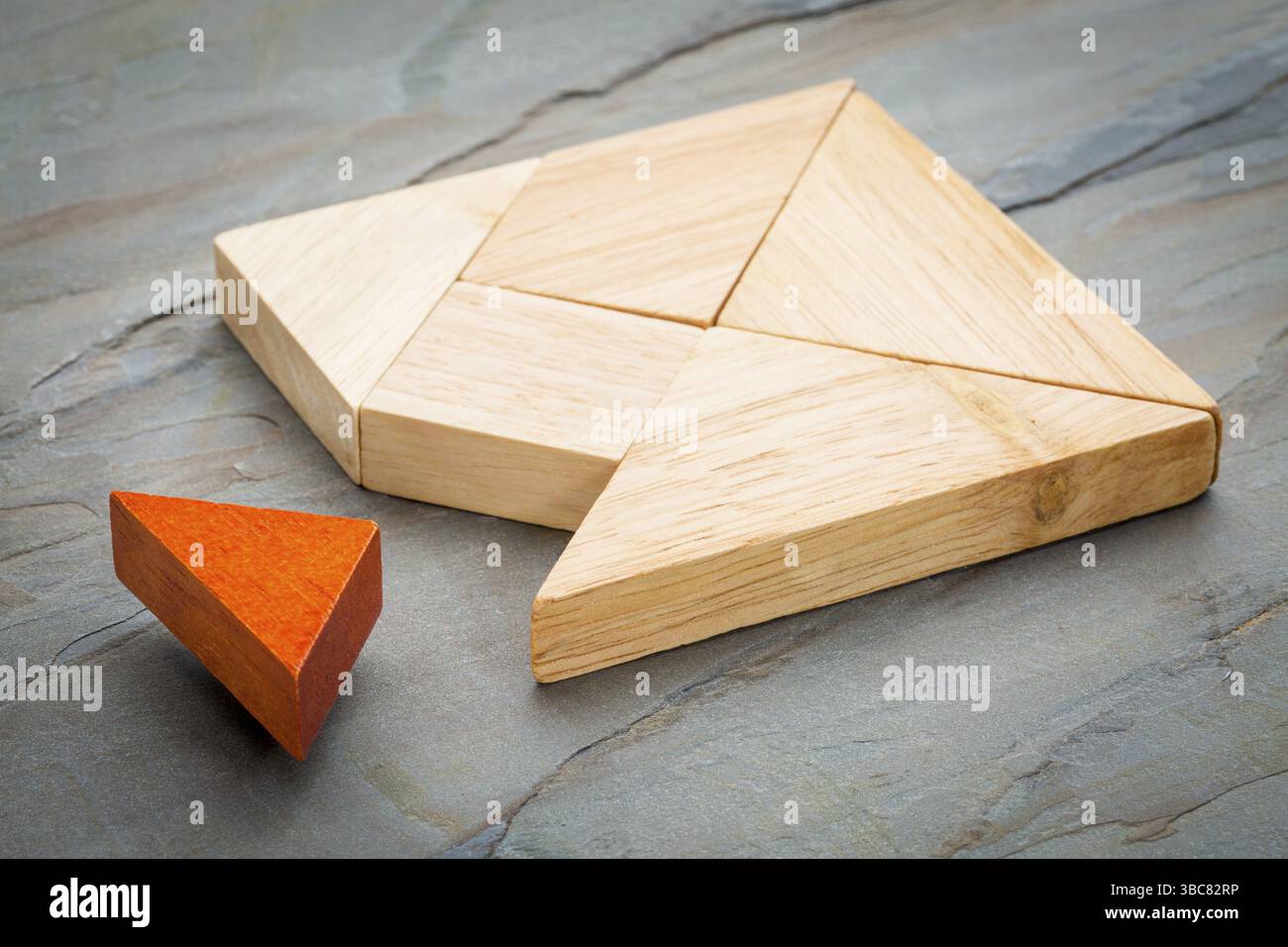 A missing piece in a square built from tangram shapes, a traditional ...