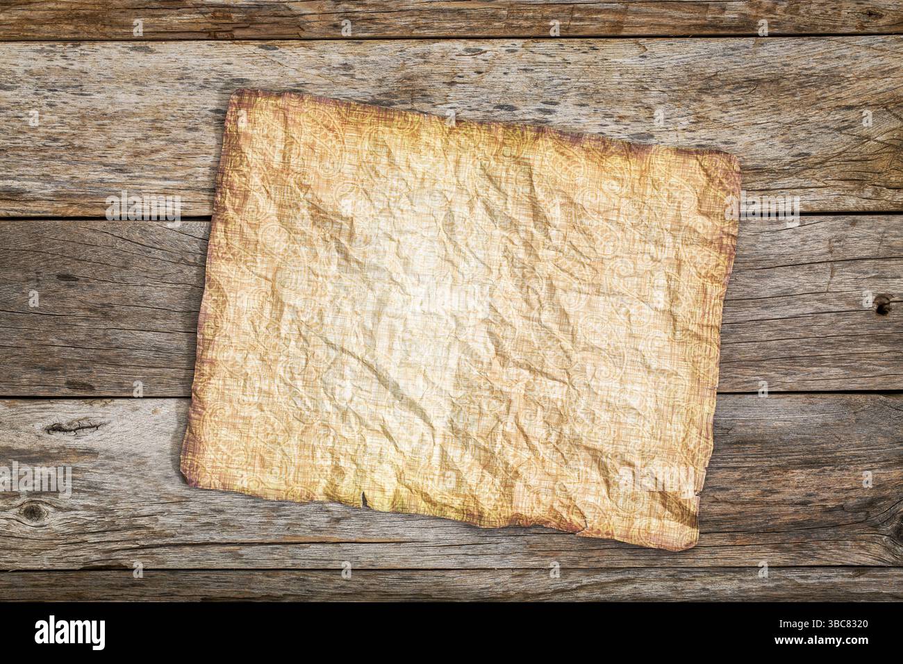 Crumpled blank sheet of antique paper with brown pattern on a rustic ...