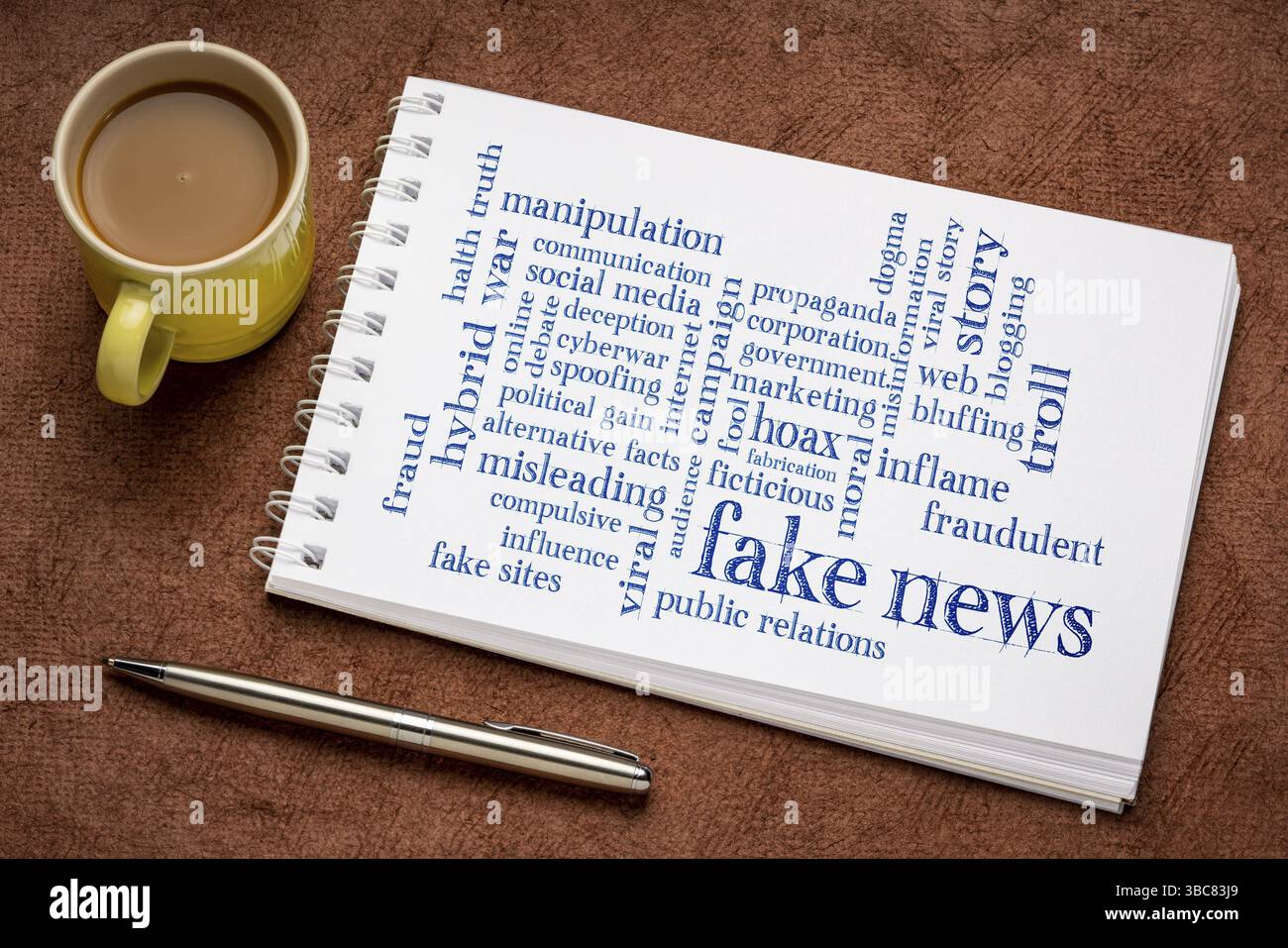 Fake news word cloud - handwriting in an art sketchbook with a cup of ...