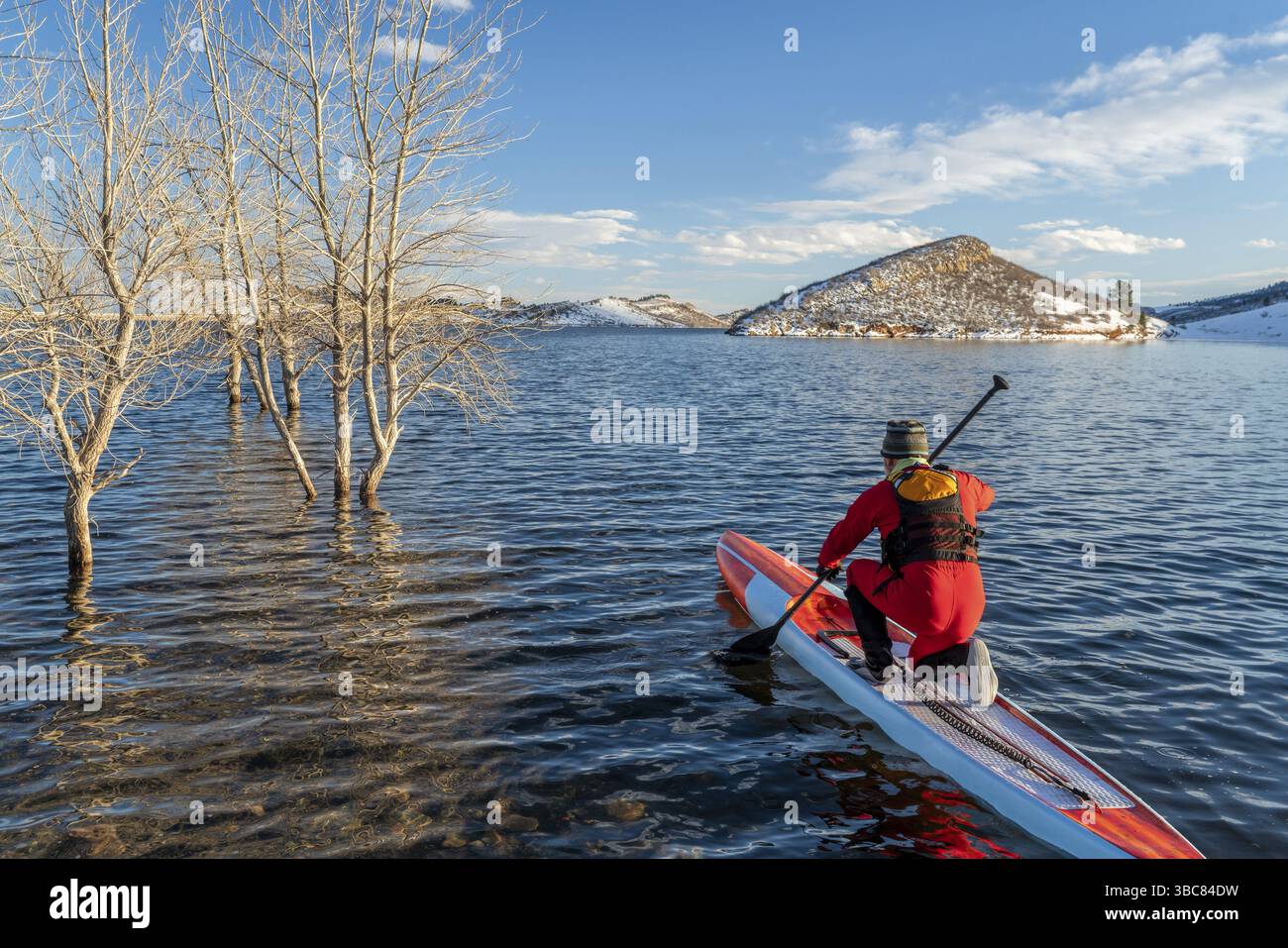 Male paddler wearing a drysuit, life jacket and safety leash is ...