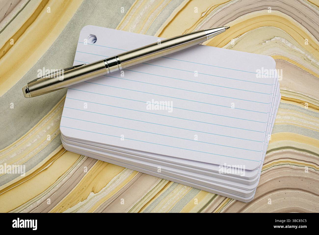 Stack of blank index card with a pen over wavy marbled paper Stock ...