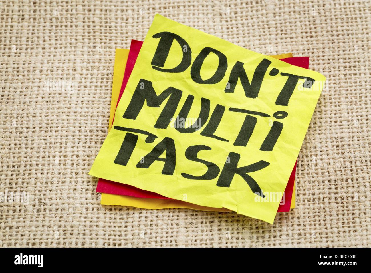 Do not multitask - efficiency advice on a sticky note against burlap canvas Stock Photo - Alamy