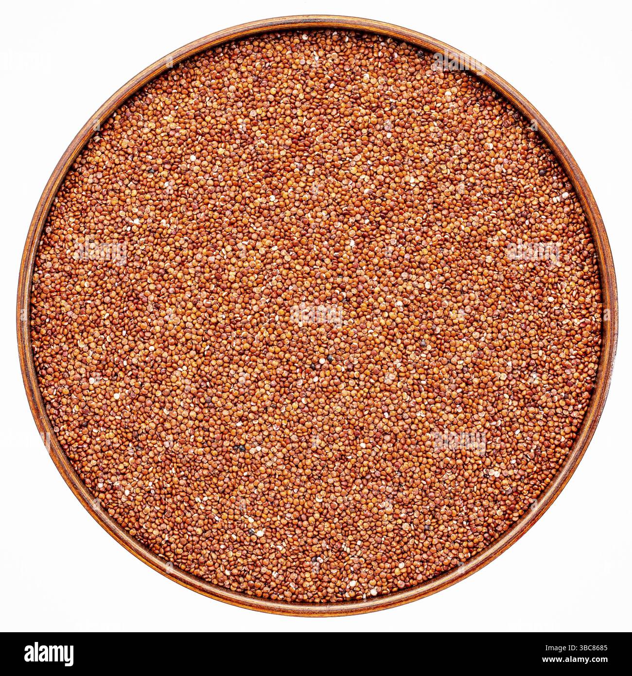 Gluten free red quinoa grain in round wooden tray isolated on white ...