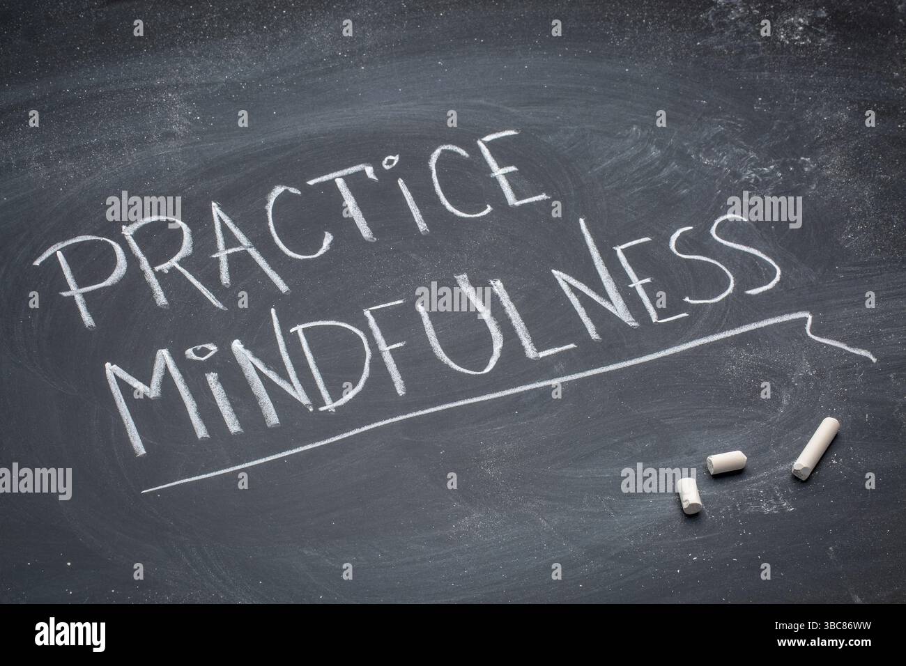 Practice mindfulness - white chalk messy handwriting on a blackboard ...
