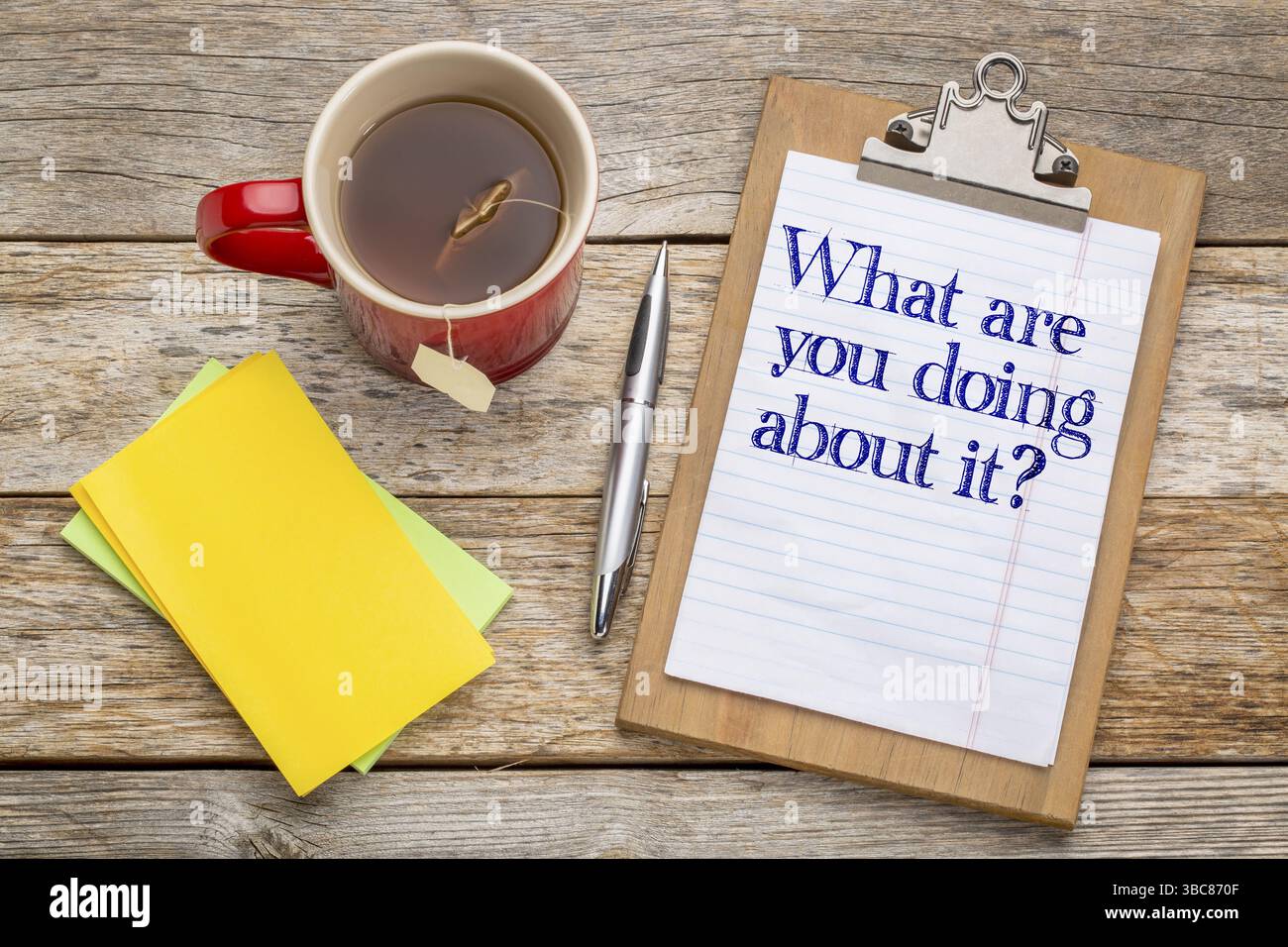 What are you doing about it? A question on clipboard with a pen, tea ...