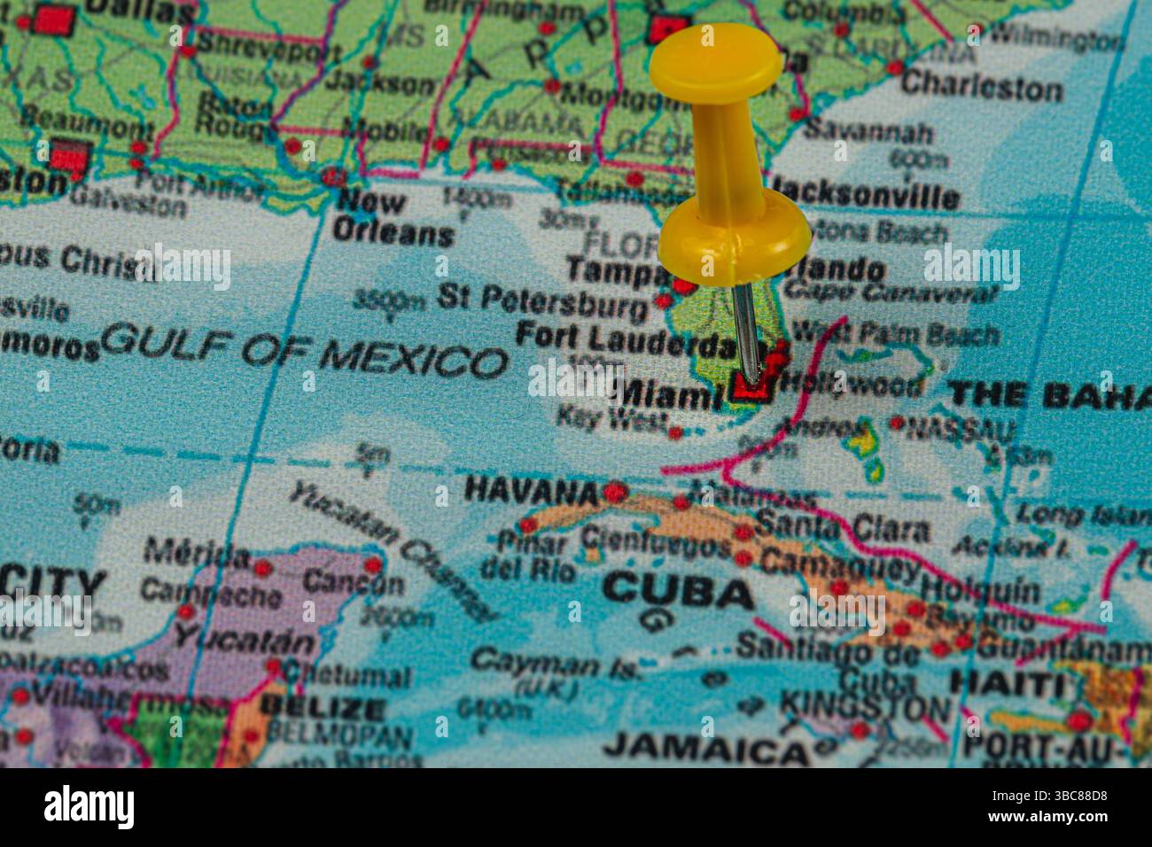 A bright yellow pushpin is placed on Miami within a colorful map of ...