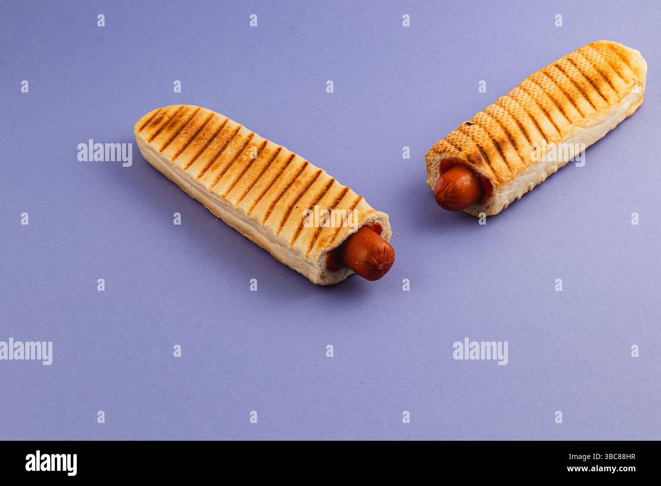 Two grilled hot dogs are placed in toasted buns, showcasing a delicious ...