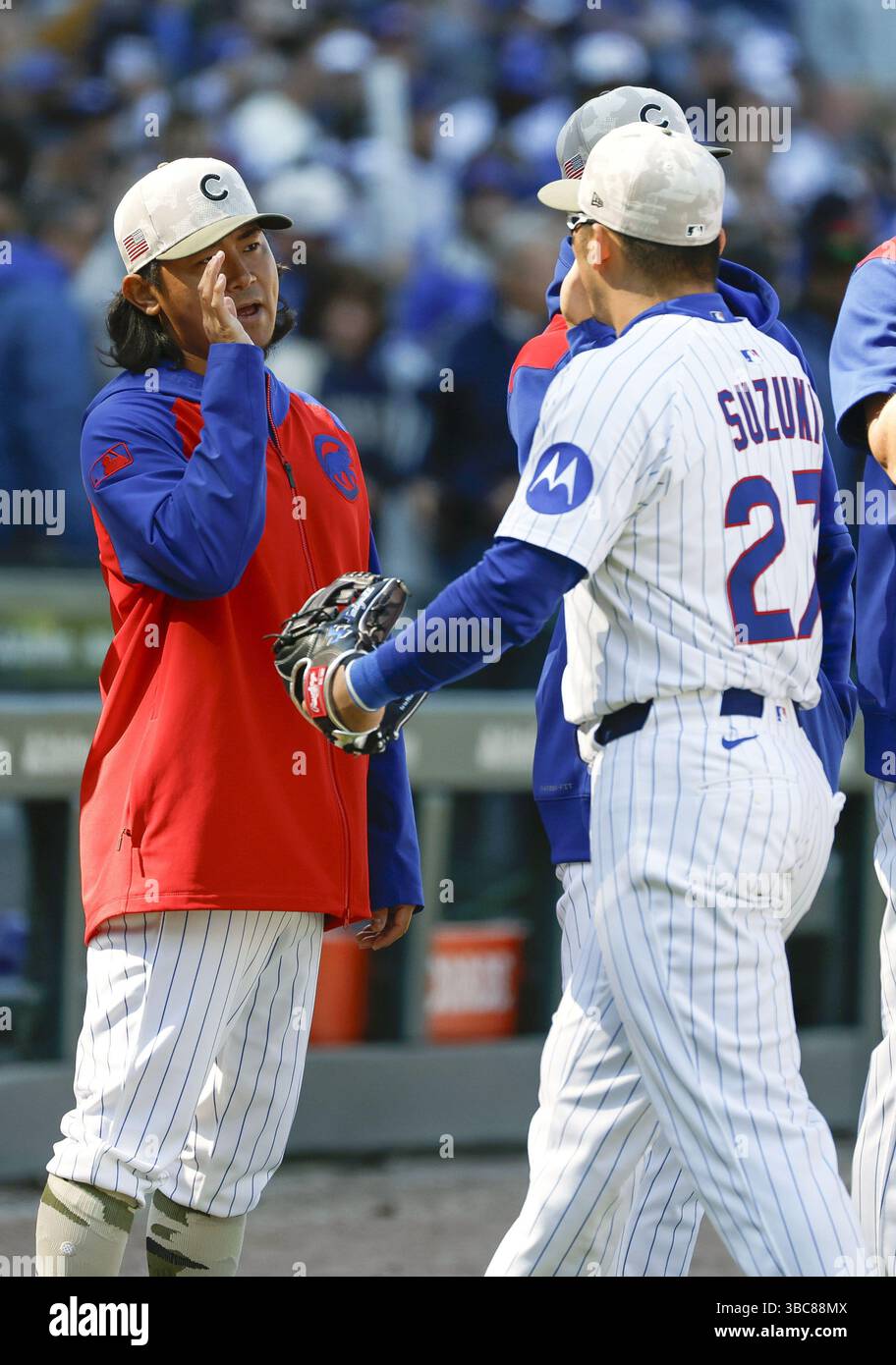 Chicago Cubs left fielder Seiya Suzuki (R) high-fives pitcher Shota ...