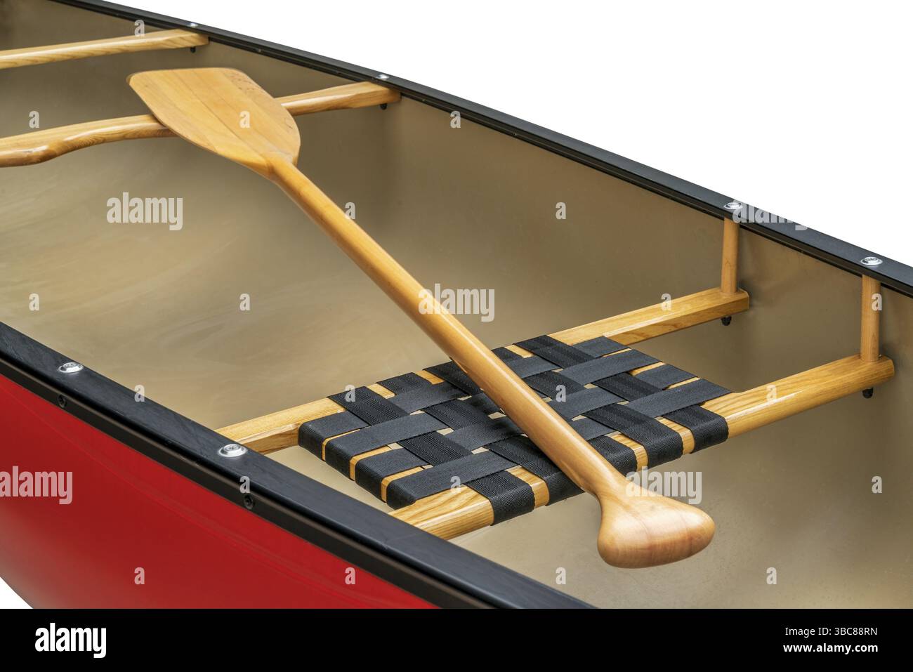 Wooden paddle inside a red canoe (midsection) with a classic seat ...