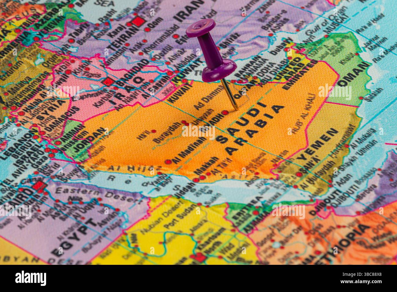 A colorful map displays Saudi Arabia, highlighted with a pushpin ...