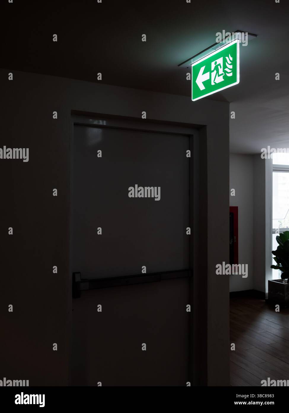 Fire exit sign. Green emergency exit sign hanging from ceiling glowing ...