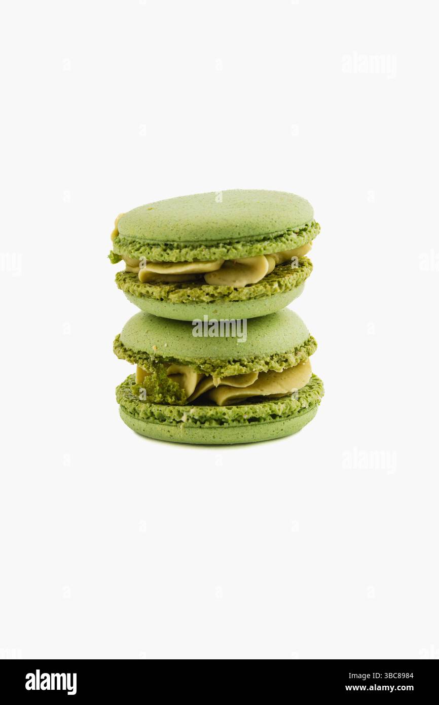 Three green macarons are stacked neatly, showcasing their delicate ...