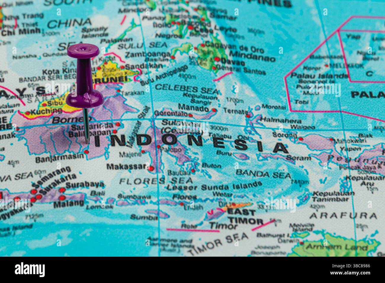 A detailed map shows Indonesia with a purple pushpin indicating the ...
