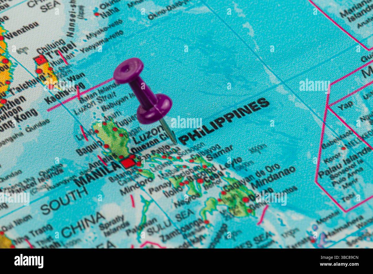 A purple pushpin marks the location of Manila on a detailed map of the ...