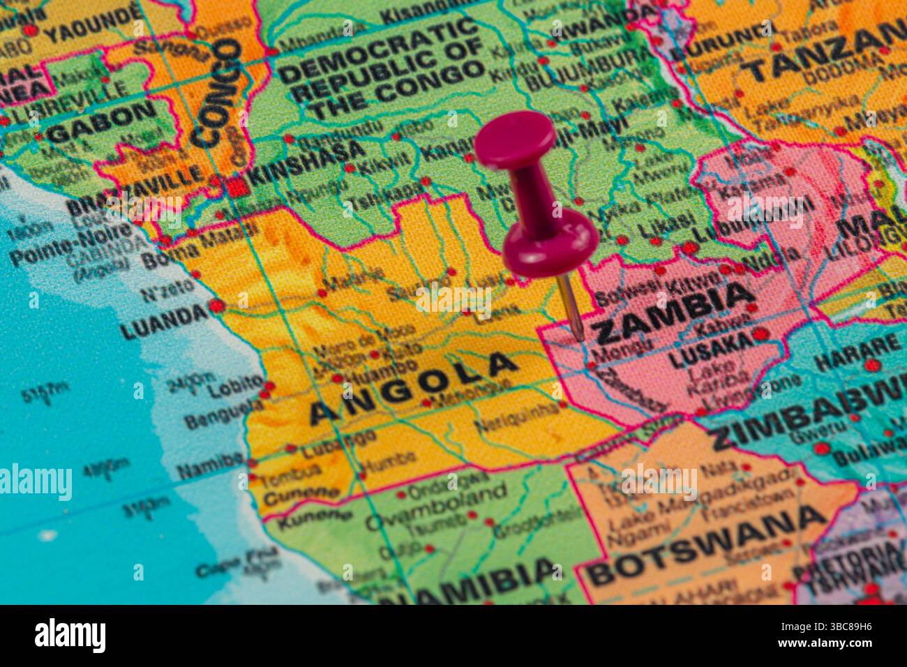 A colorful map of Africa features Angola marked by a pink pushpin ...