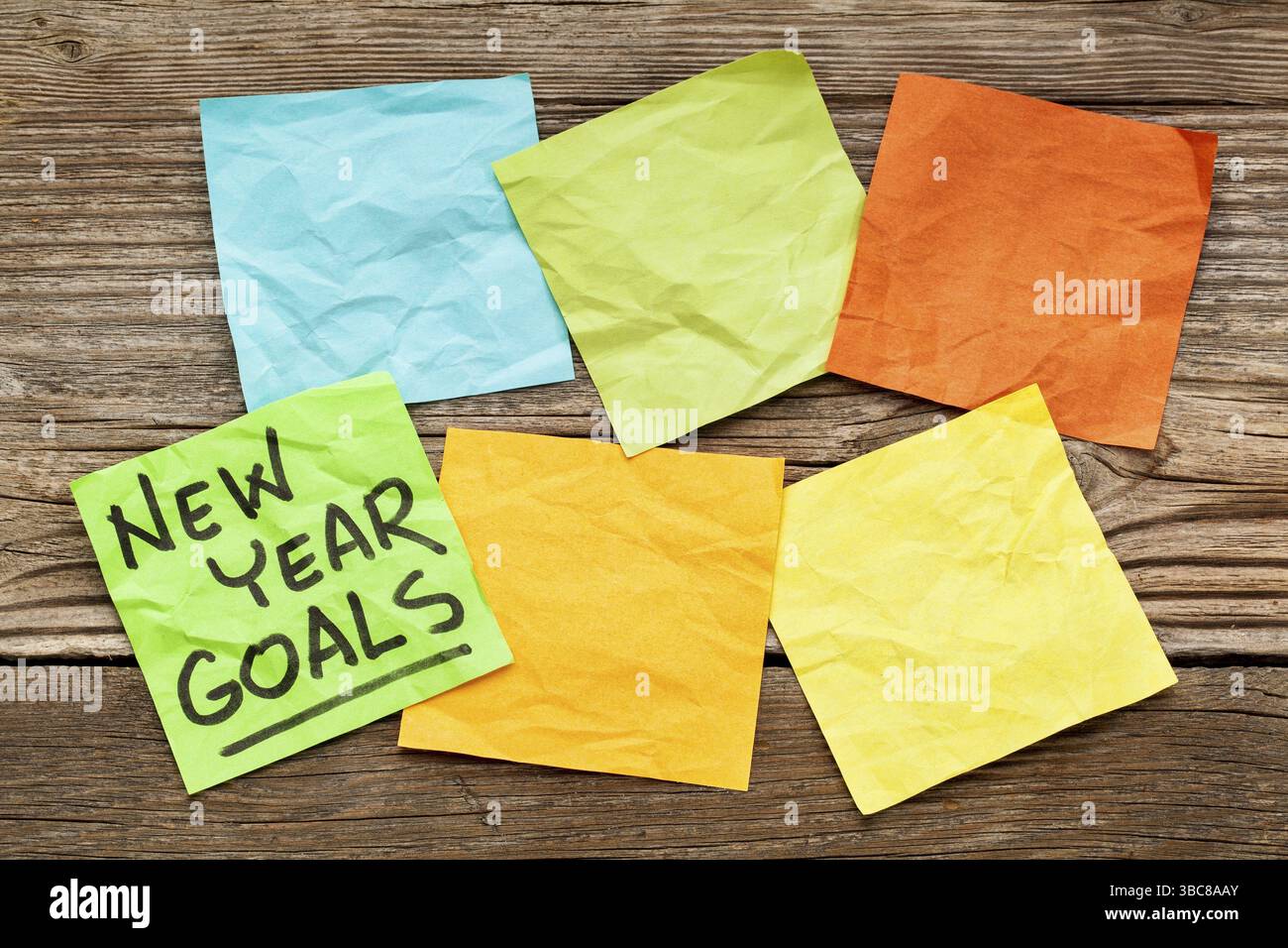 New Year goals - handwriting on a sticky note against grained wood with ...
