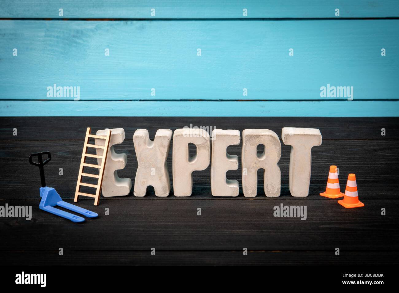 Expert Concept. Concrete alphabet letters on a black wooden texture ...