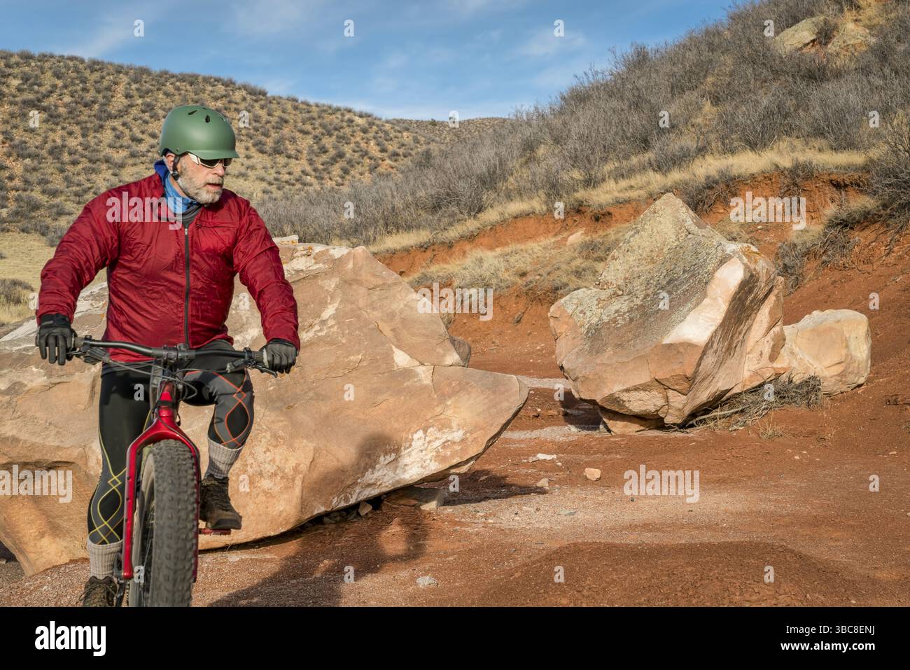 A senior male riding a fat bike on mountain desert trail in Red ...